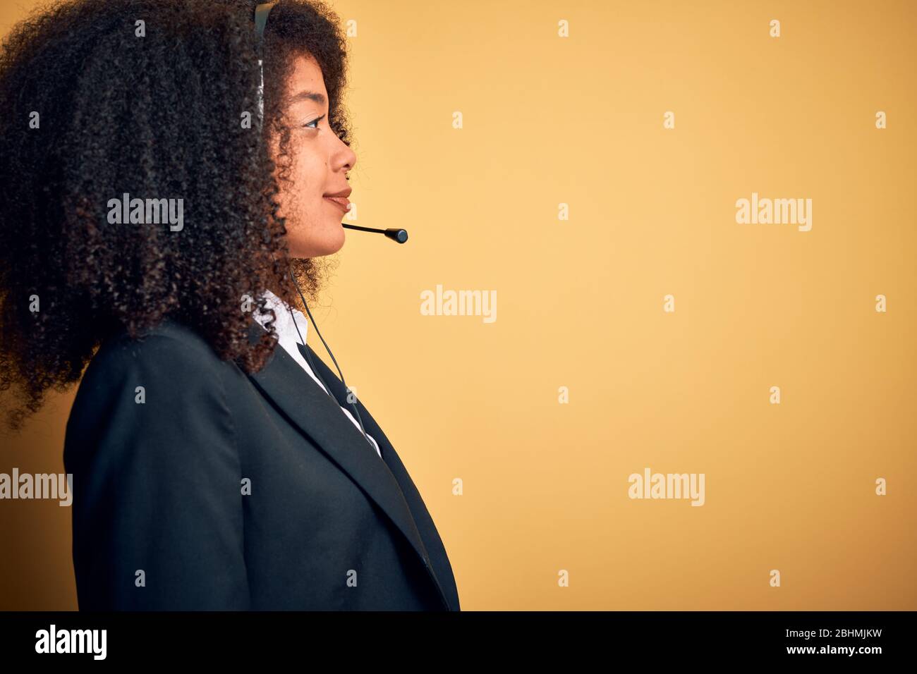 Young african american operator woman with afro hair wearing headset ...