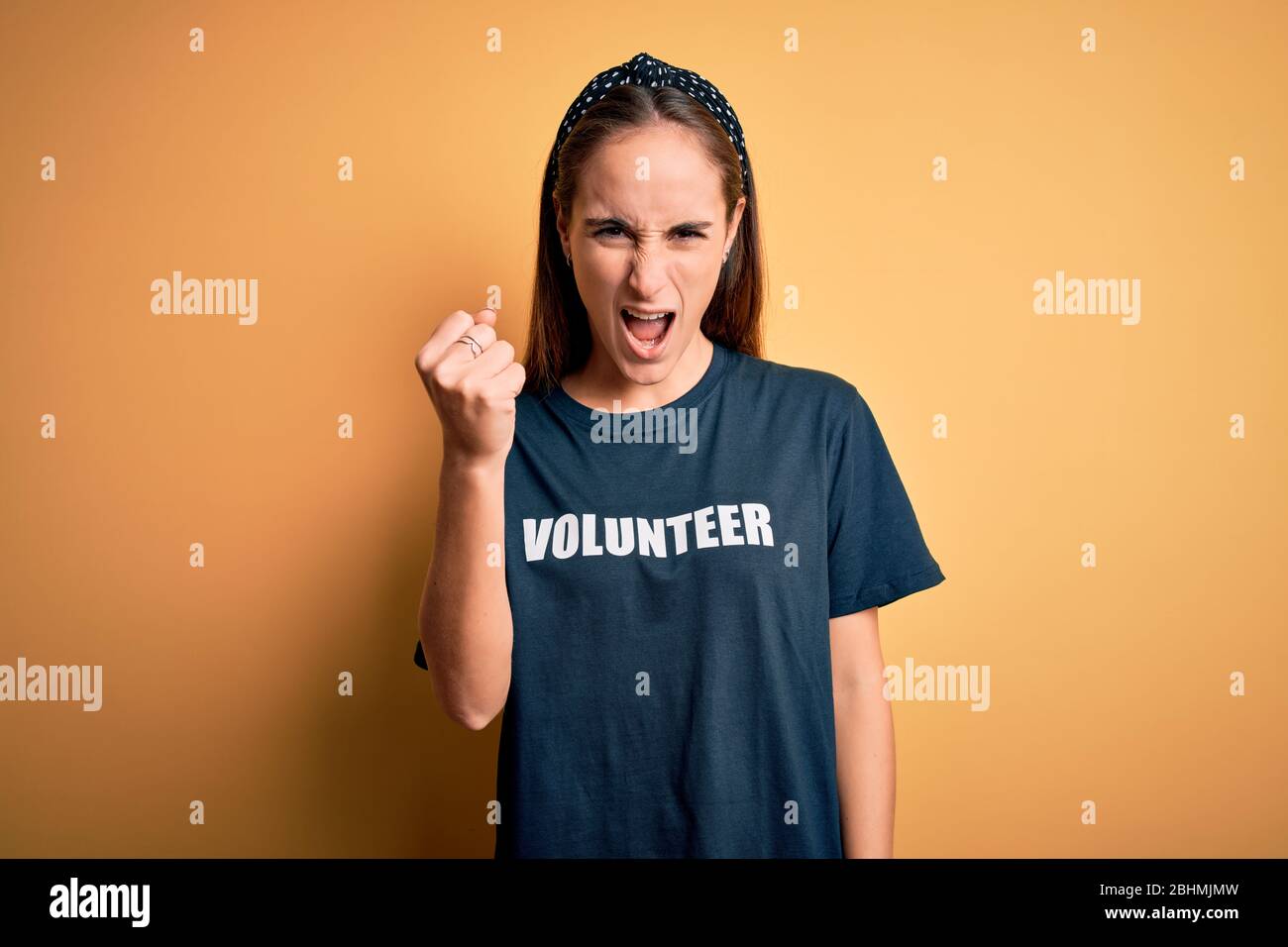 Young beautiful woman wearing volunteer t-shirt doing volunteering over ...
