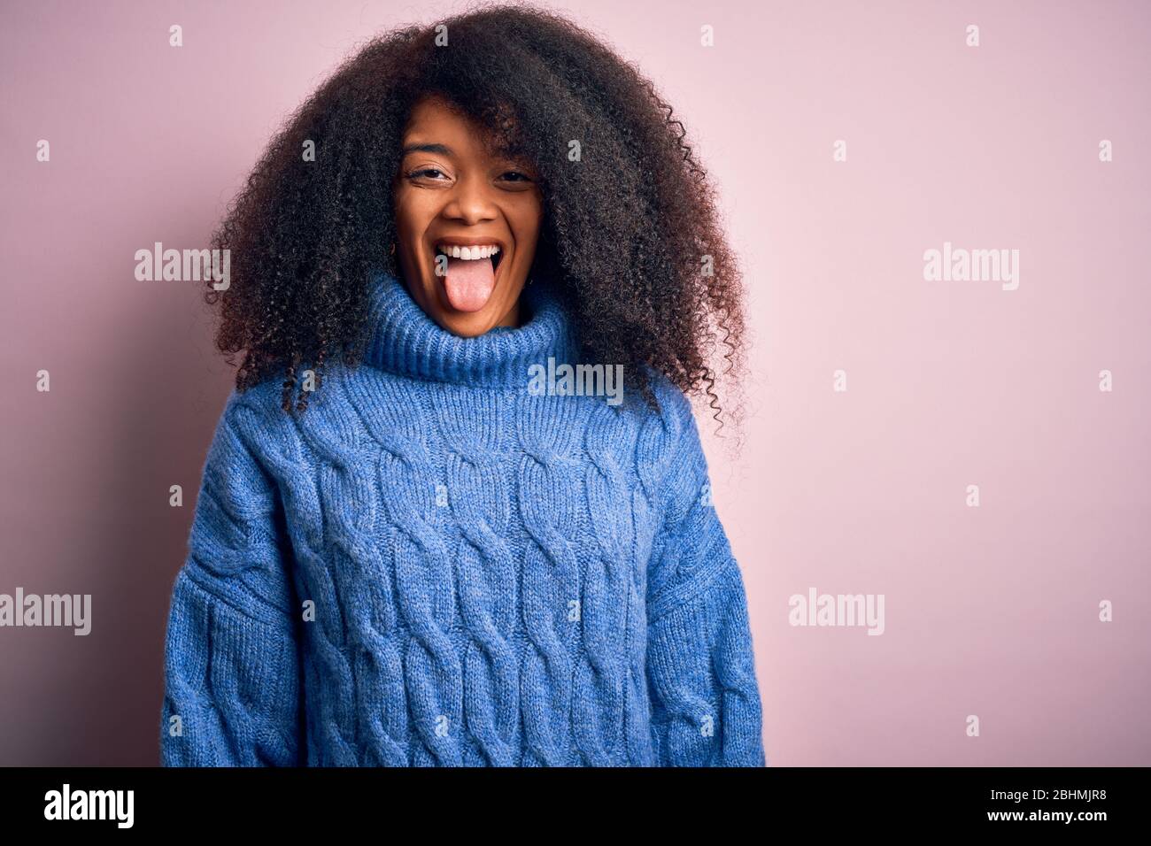 Young beautiful african american woman with afro hair wearing winter ...