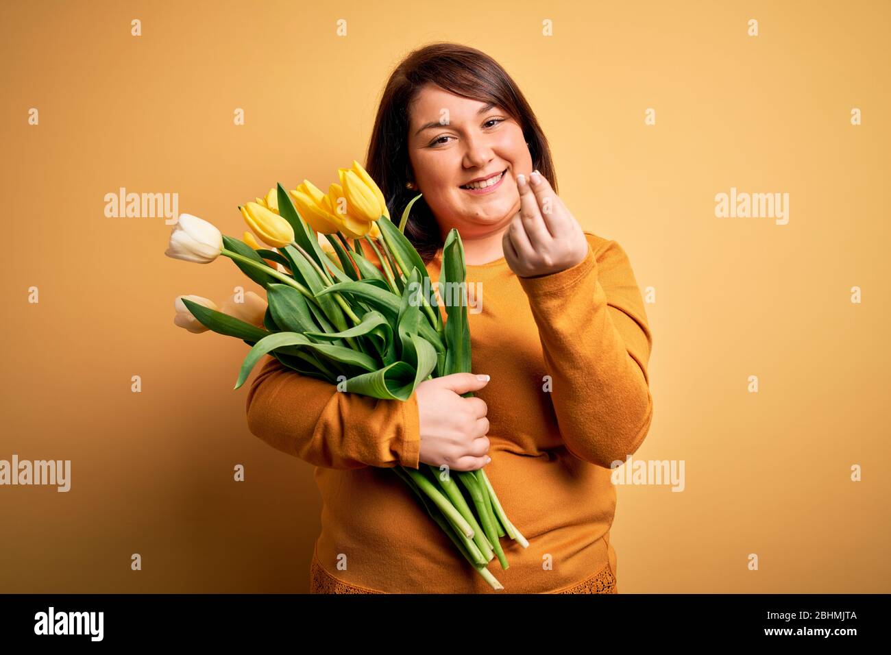 Beautiful plus size woman holding romantic bouquet of natural tulips ...