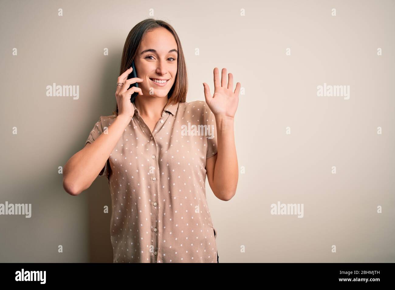Young beautiful woman having conversation talking on the smartphone ...