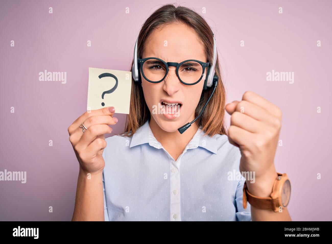 Beautiful call center agent woman working using headset holding ...