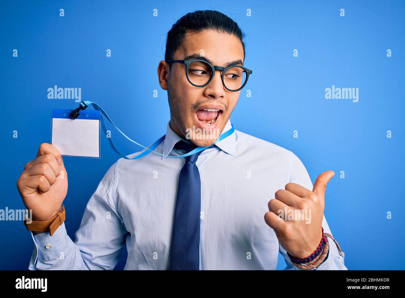 Young brazilian call center agent man holding id identification card ...