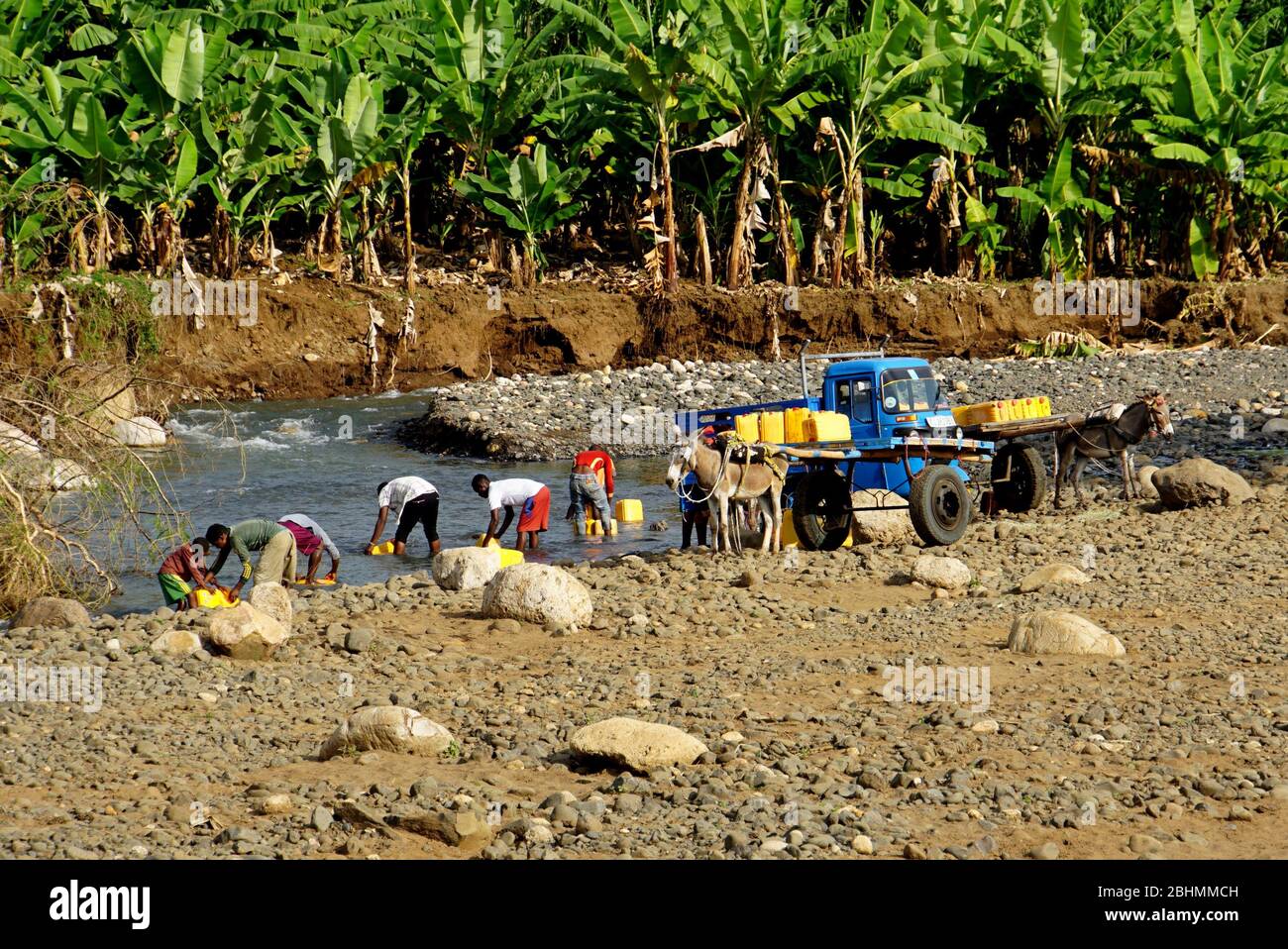 Men collecting Water from a shallow River Stock Photo - Alamy