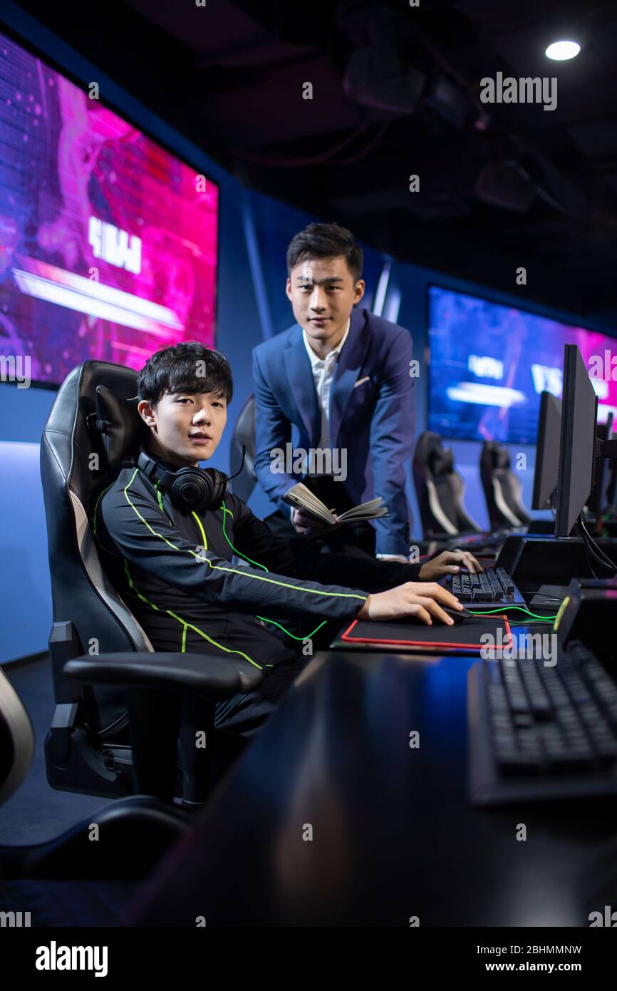 Young Chinese man coaching gamer playing esports Stock Photo - Alamy