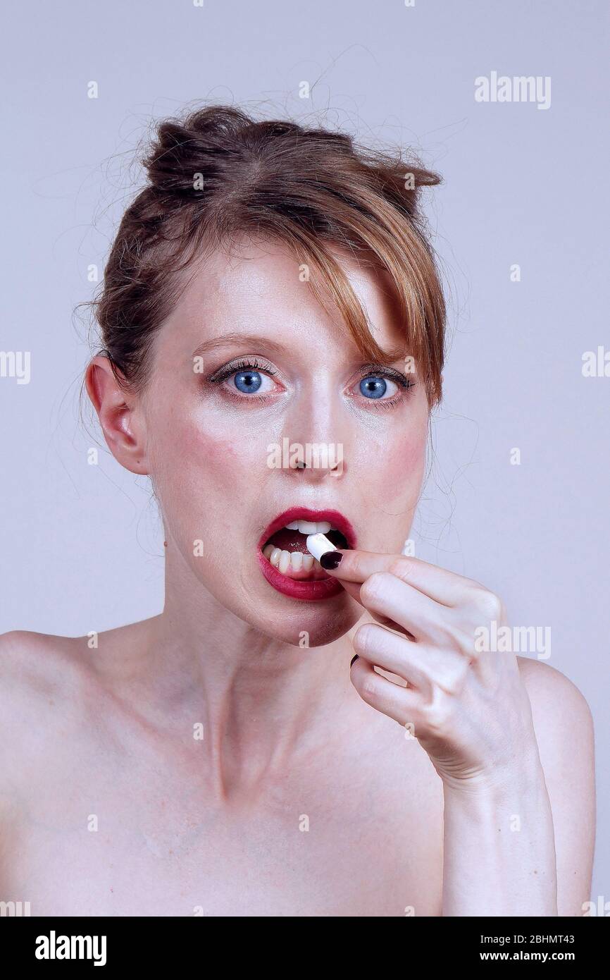 Woman taking pill red lips hi-res stock photography and images - Alamy