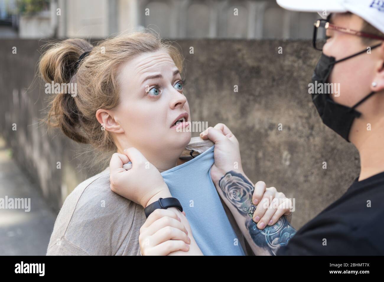 Scared young caucasian girl woman is attacked assaulted by masked man ...