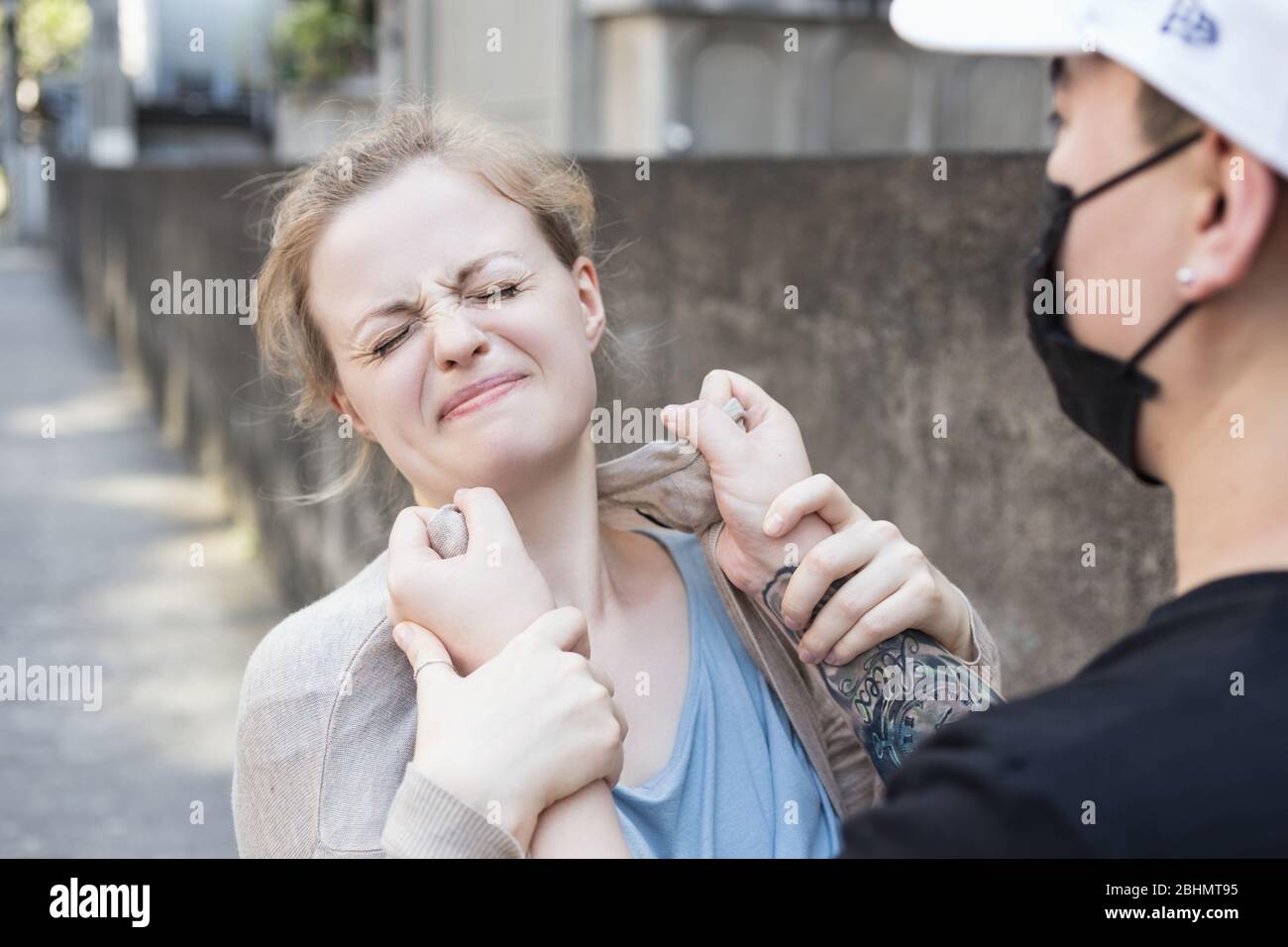 Scared young caucasian girl woman is attacked assaulted by masked man ...