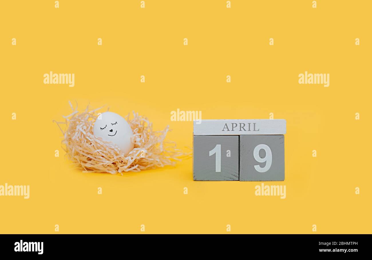 cute white Easter egg with a black marker drawn face sleep in a paper ...