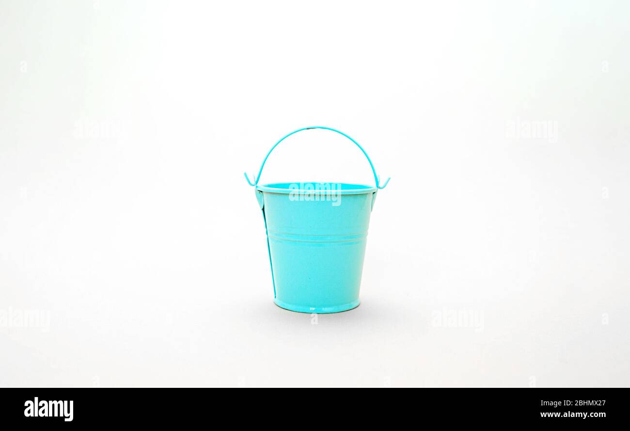 Blue metal miniature bucket with raised handles on a white background ...