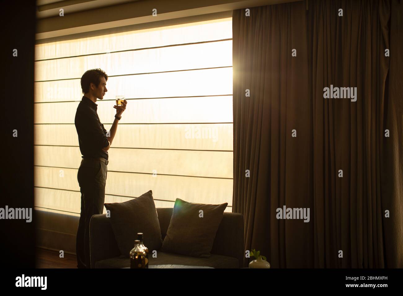 Young Chinese businessman drinking alcohol in front of window Stock ...