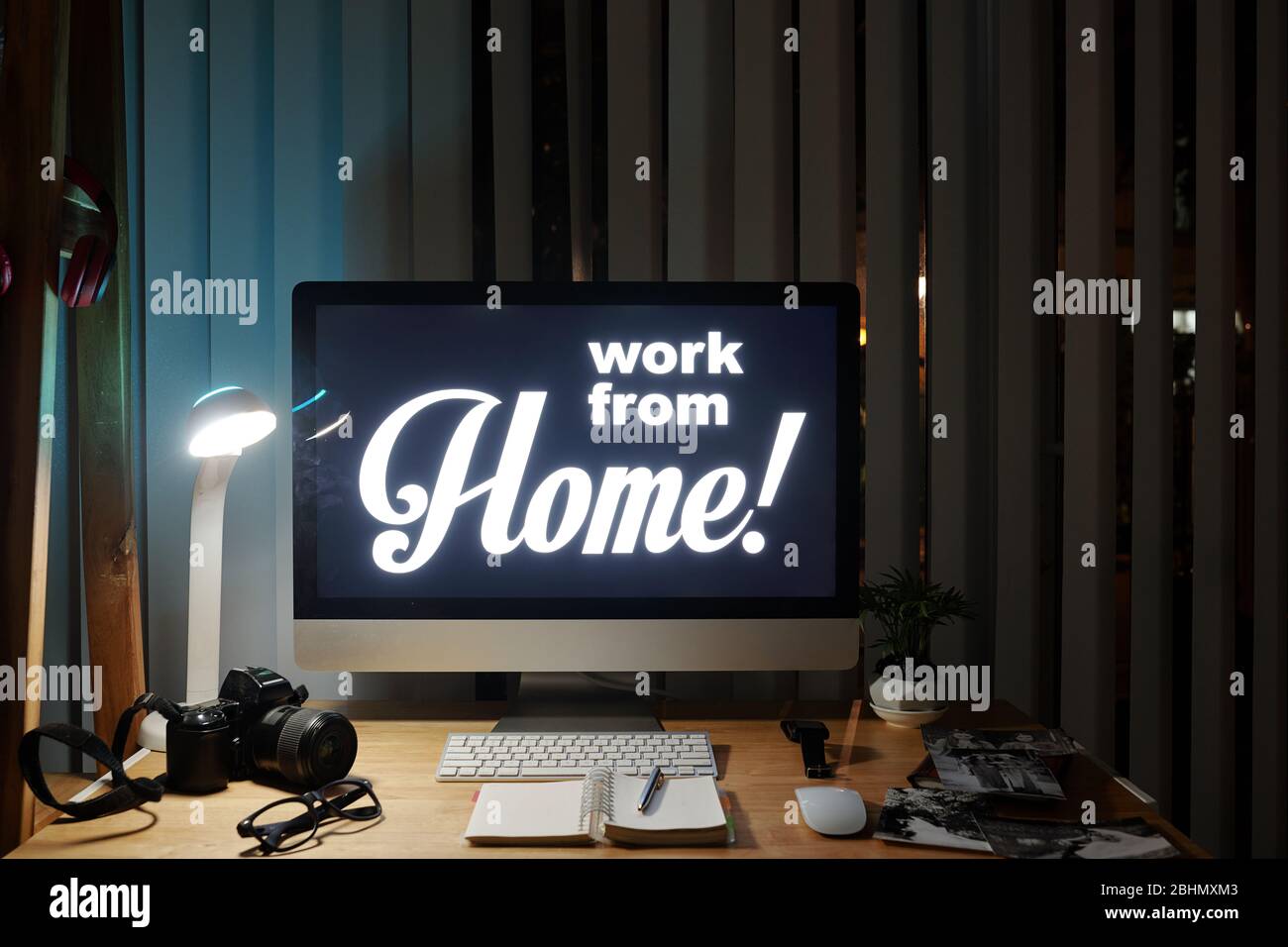 Glowing computer monitor with work from home inscription in dark room ...