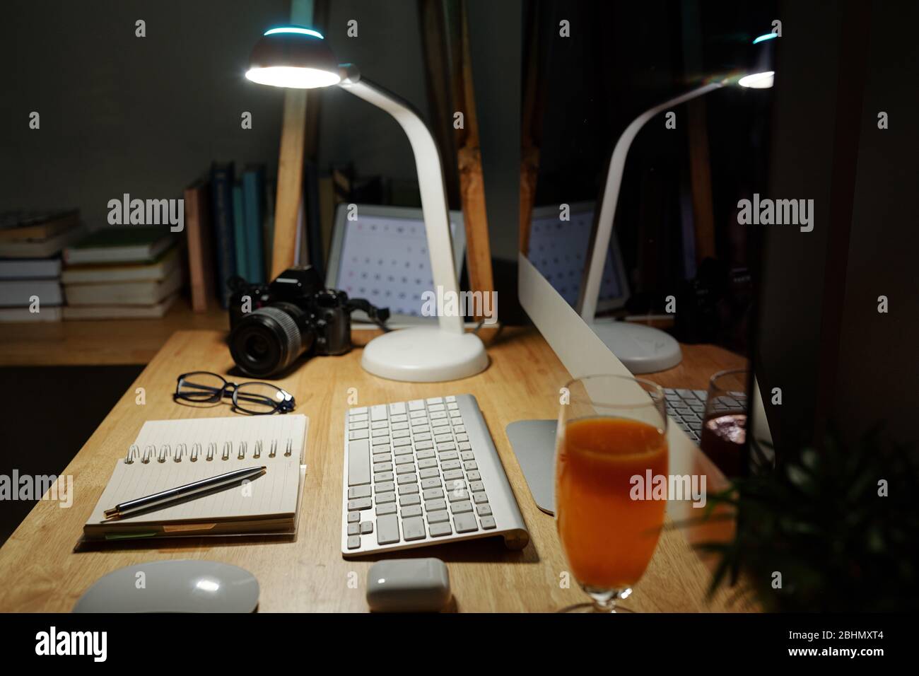 Wooden desk with computer, planner and lamp. Workplace of person ...