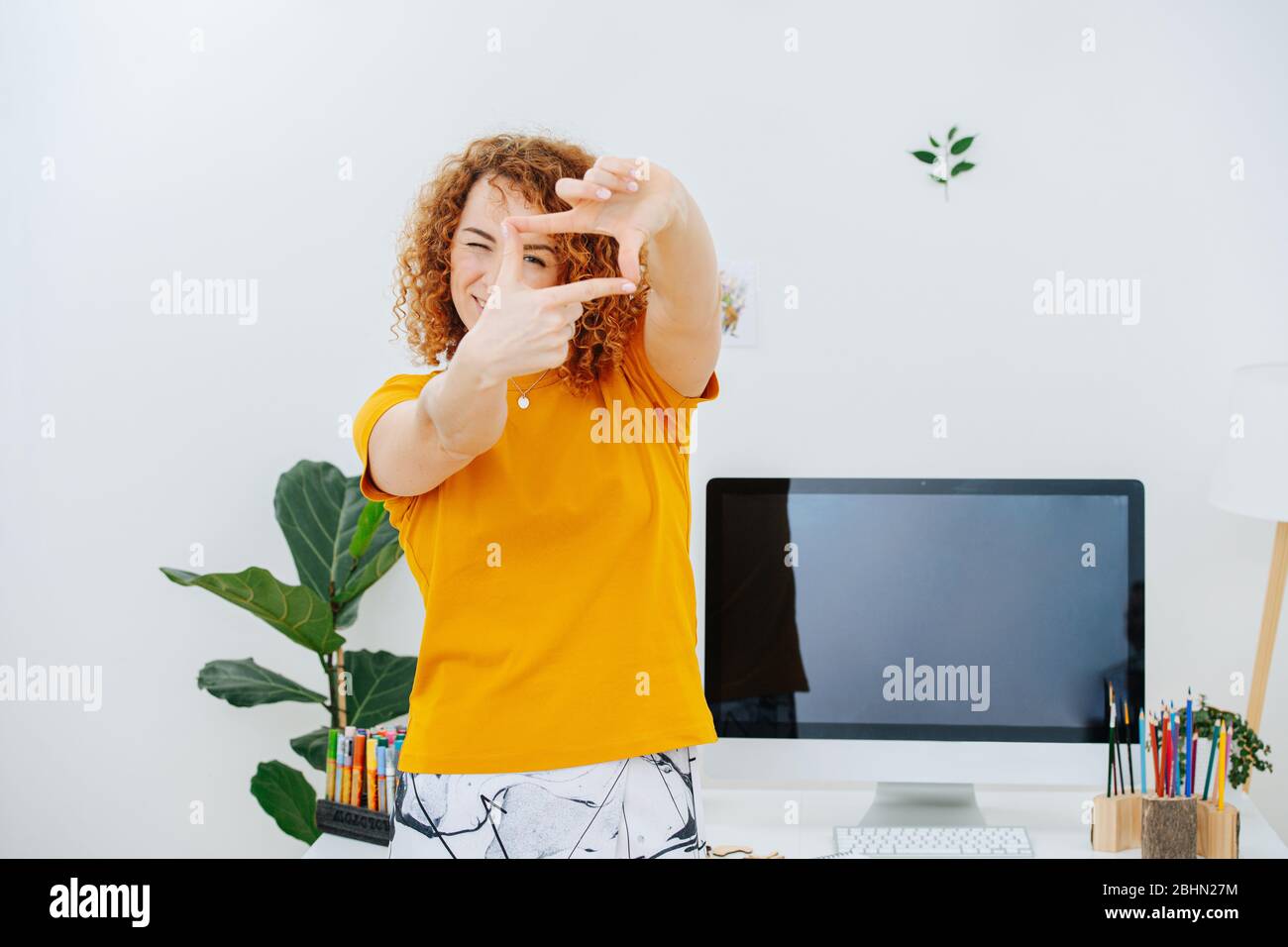 Woman making finger frame gesture and looking through Stock Photo - Alamy