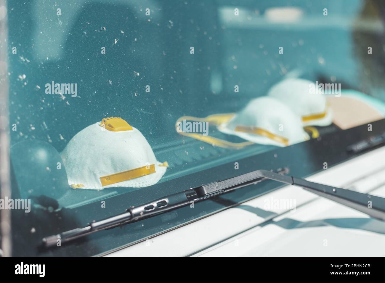 Face mask or surgical mask is lying in a car behind the front shield ...