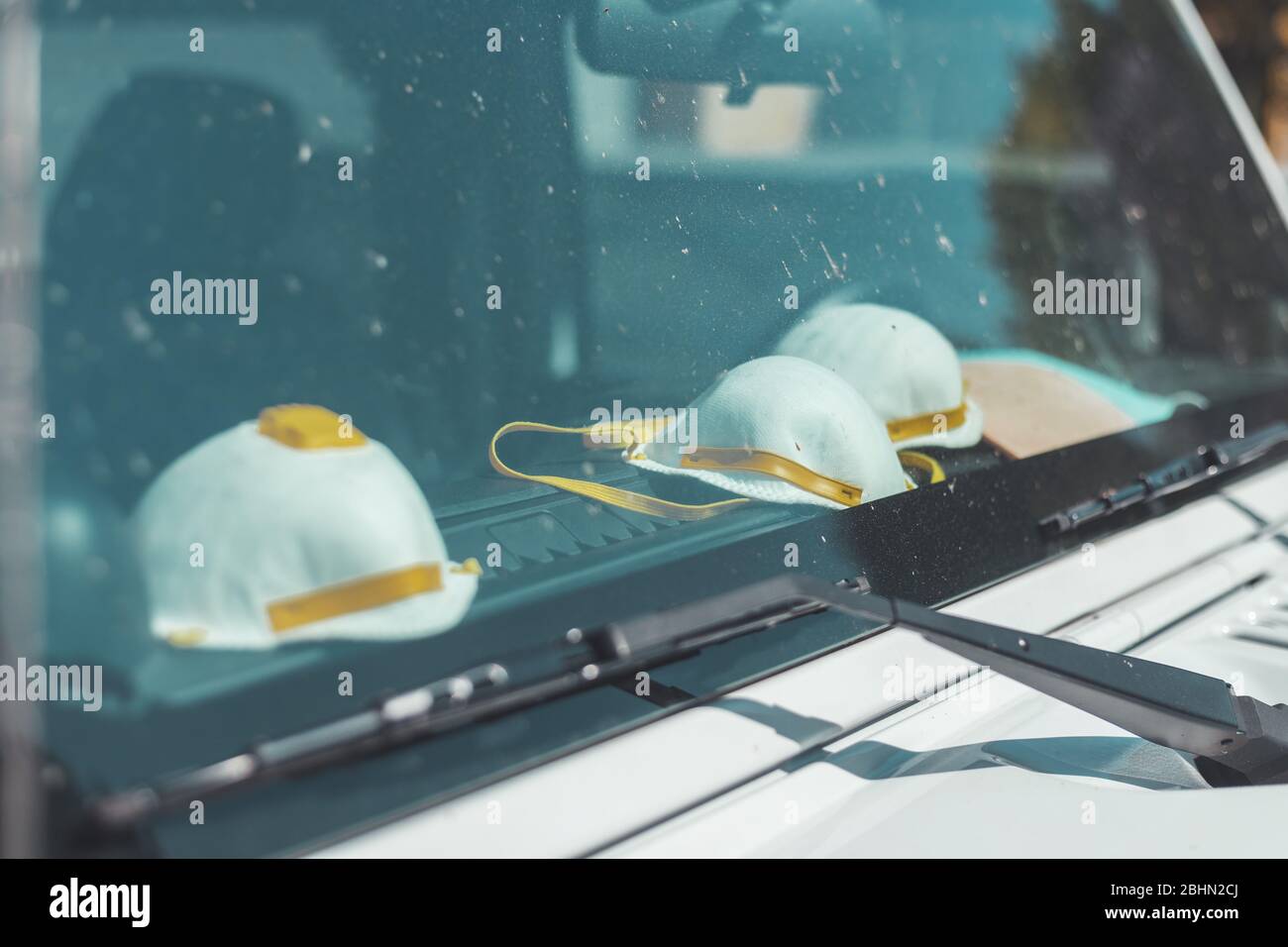 Face mask or surgical mask is lying in a car behind the front shield ...