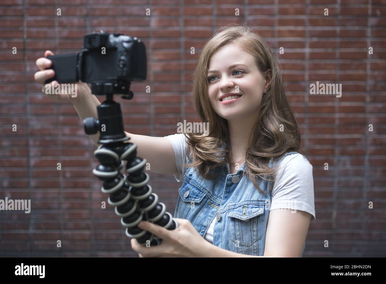 Smiling young caucasian girl woman making a video blog (vlog) with ...