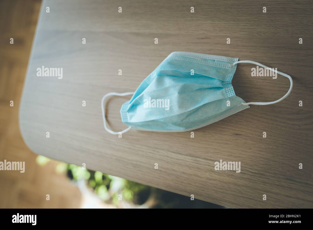 Face mask or surgical mask is lying on a wooden desk, daily routine ...