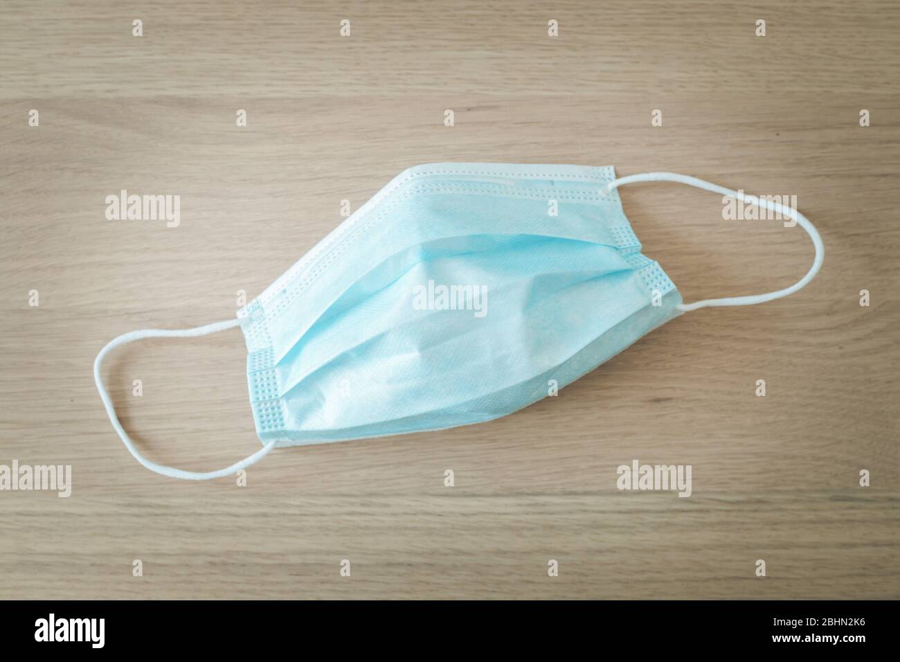 Face mask or surgical mask is lying on a wooden desk, daily routine ...