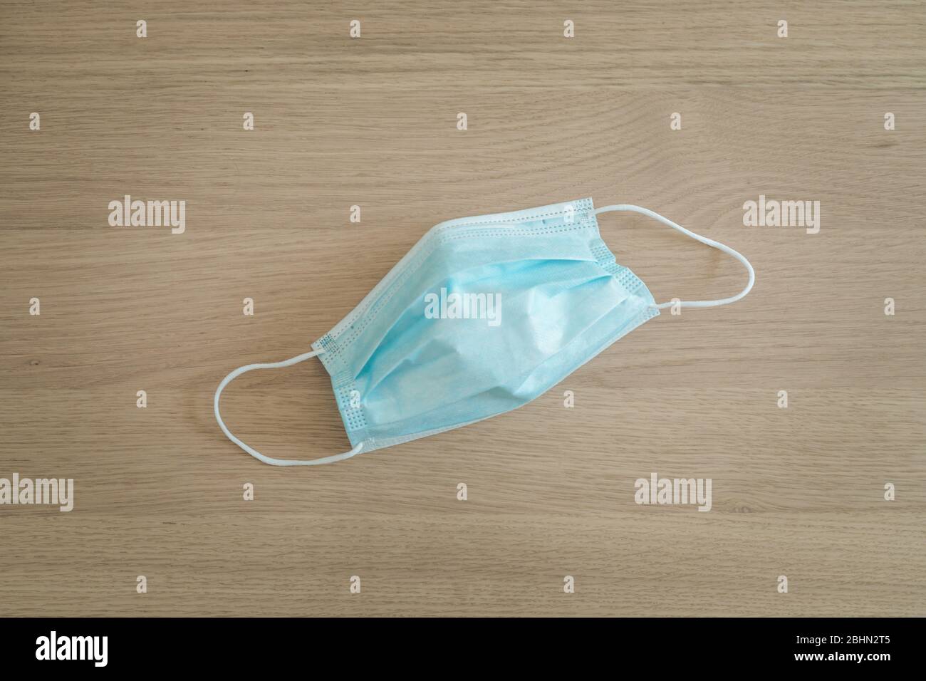 Face mask or surgical mask is lying on a wooden desk, daily routine ...