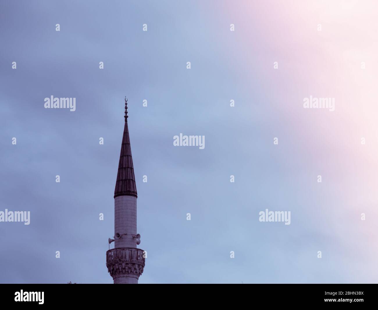 Minaret of a Muslim mosque on the background of the cloudy sky. minaret ...