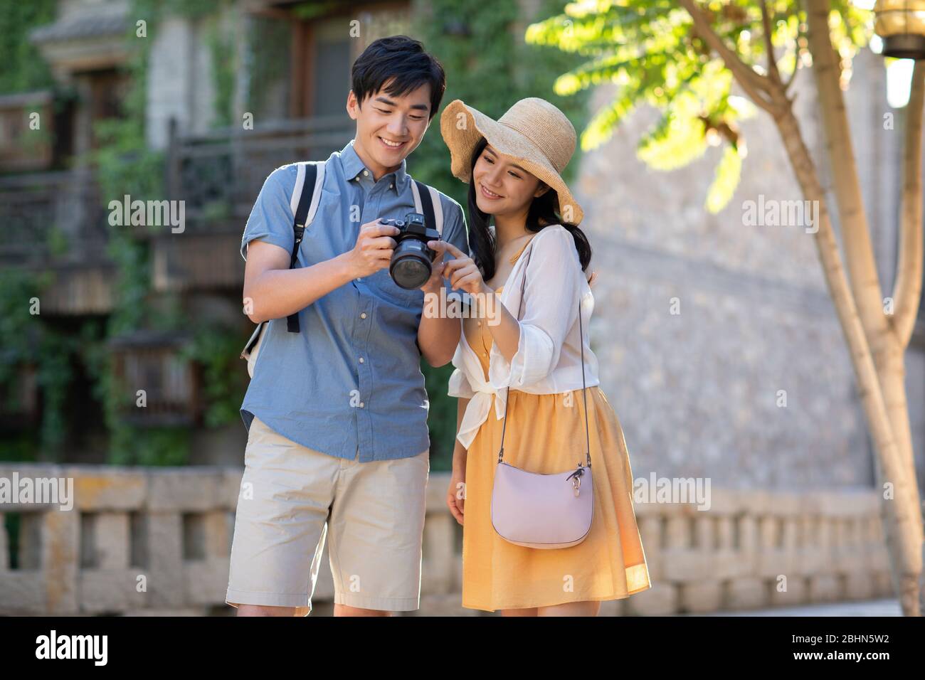 Happy young Chinese couple using camera outdoors Stock Photo - Alamy
