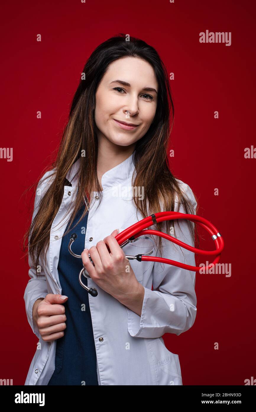 Cheerful doctor in medical clothes with phonendoscope around her neck ...