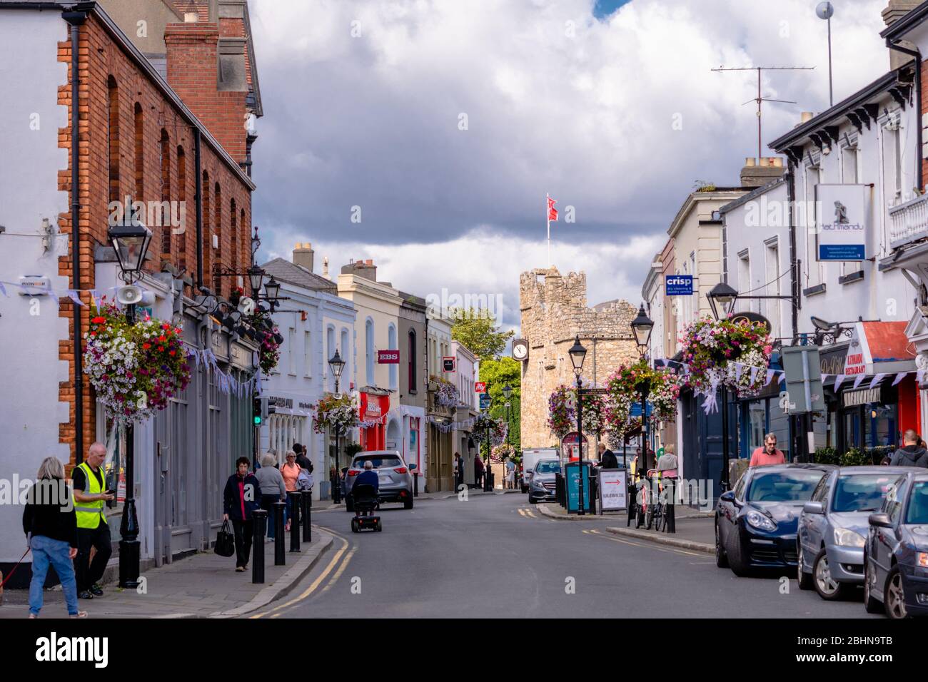 Main street with many shops and pubs in Dalkey, Ireland. Pedestrians ...