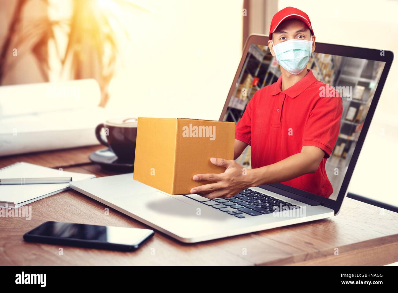 delivery man in red shirt with hygienic mask, holding goods order in ...