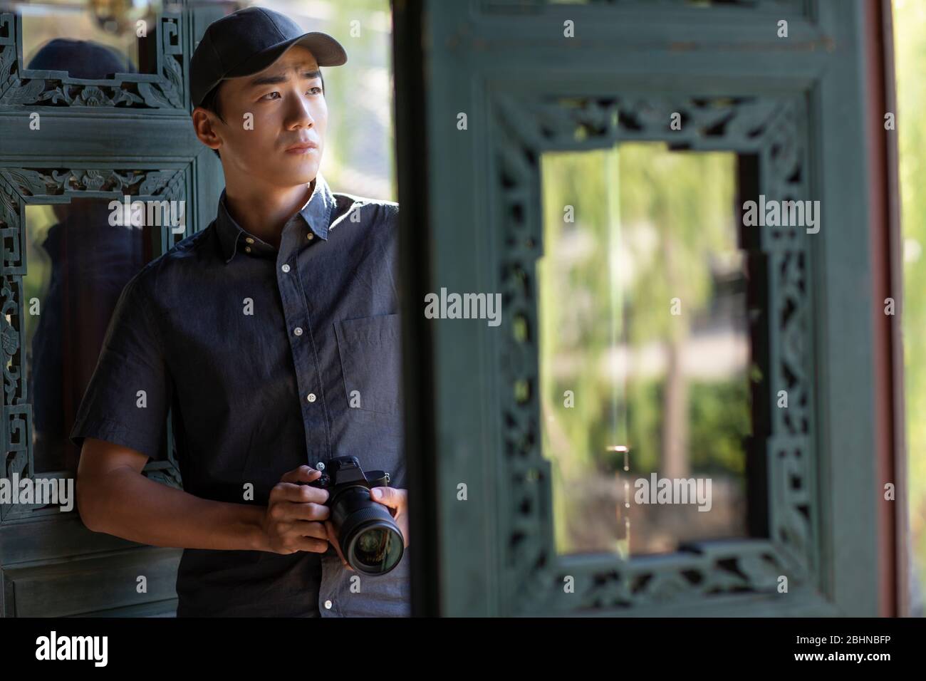 Young Chinese photographer using camera Stock Photo - Alamy