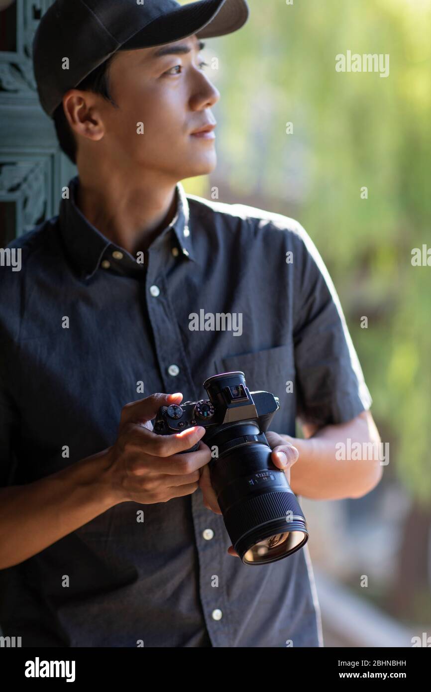 Young Chinese photographer using camera Stock Photo - Alamy