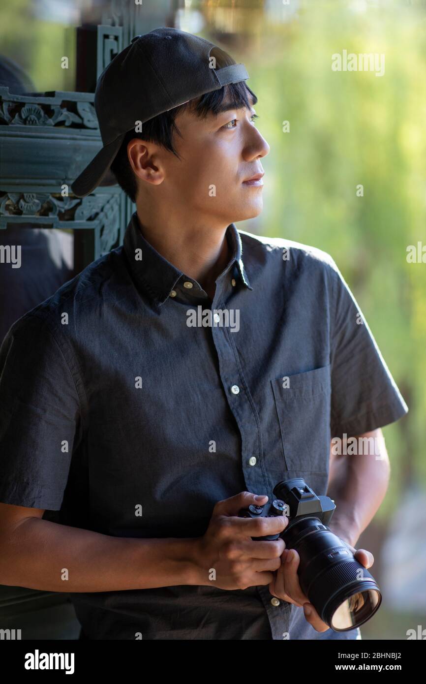 Young Chinese photographer using camera Stock Photo - Alamy