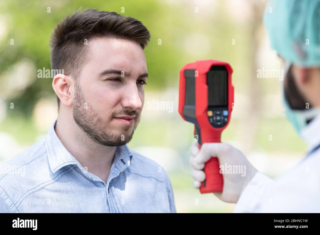 Doctor Man Use Infrared Forehead Thermometer Gun to Check Body ...