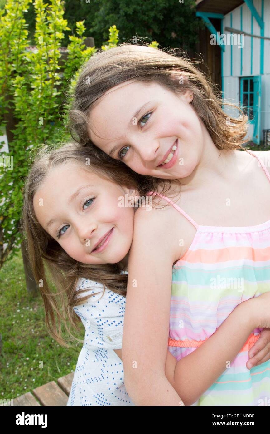 Happy funny girl sisters hugging and smiling Stock Photo - Alamy