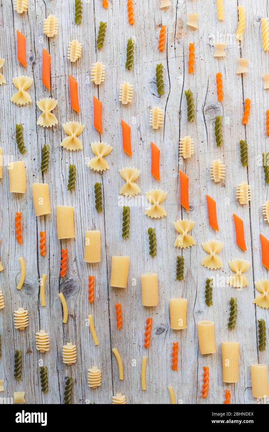 colourful mix of different noodles on wooden background photographed ...