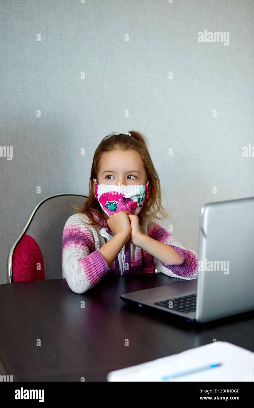 Schoolgirl studying at home with a notebook and doing school homework ...