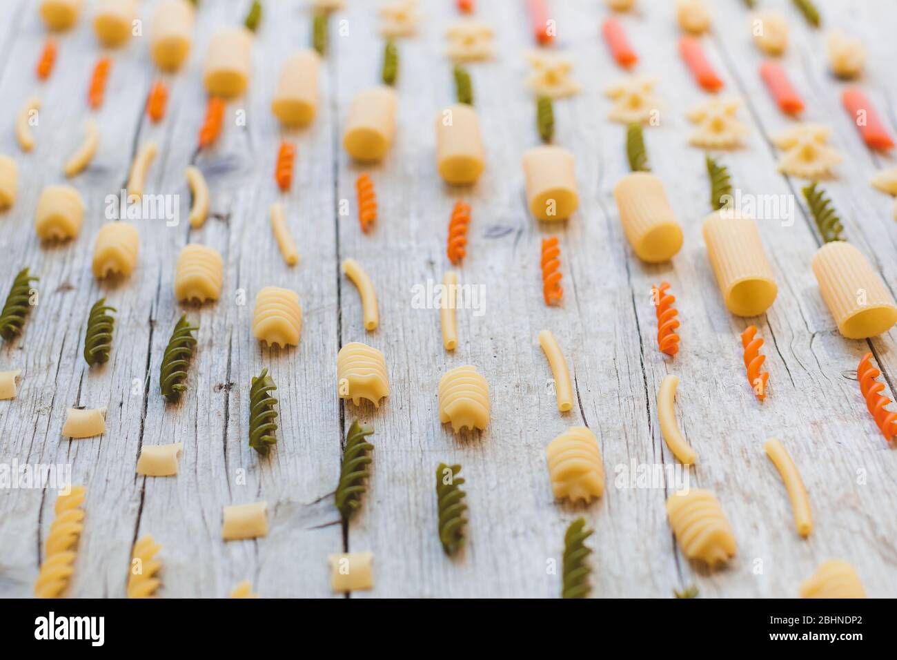 colourful mix of different noodles on wooden background photographed ...