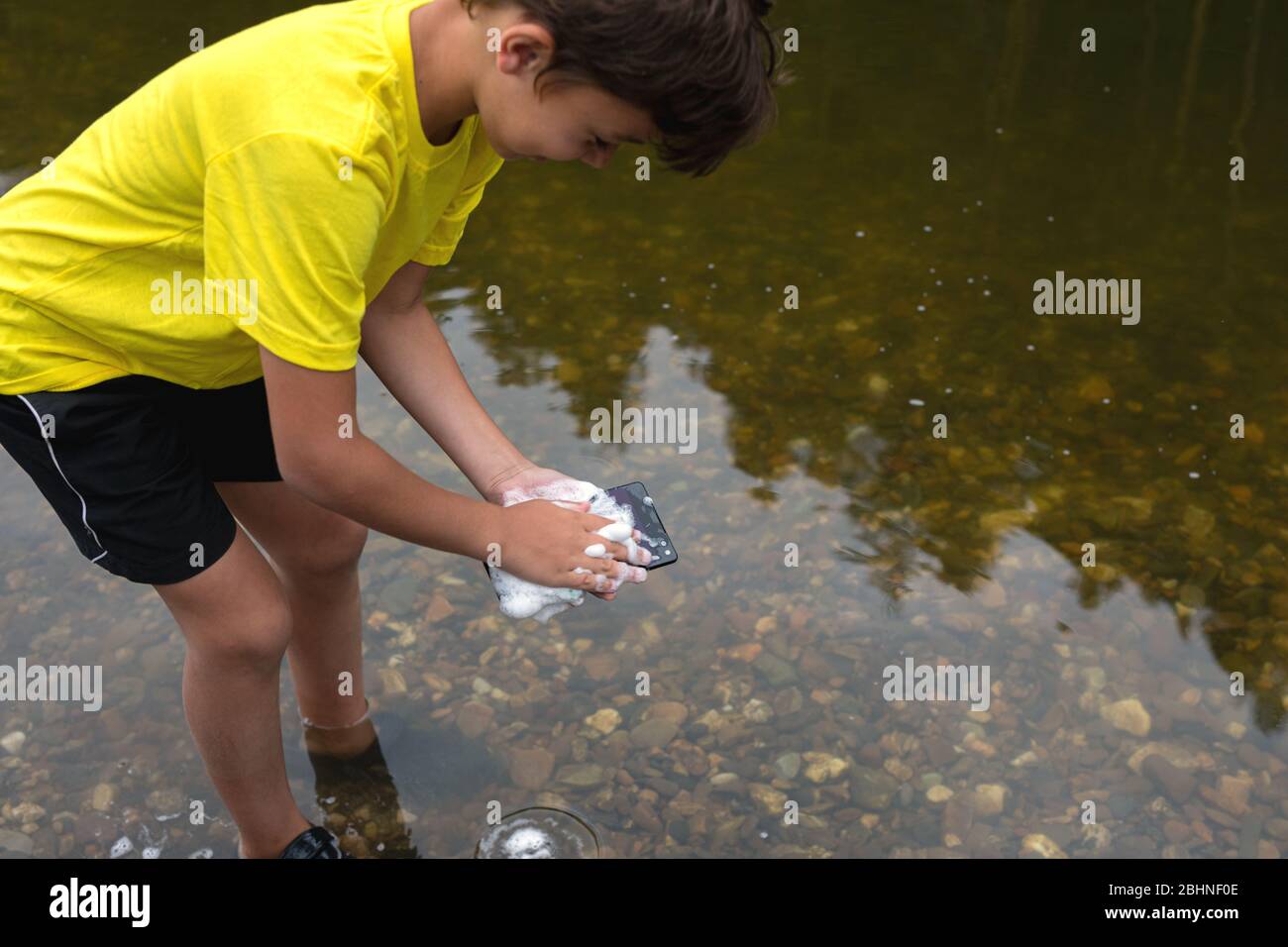 9 year old boy washes mobile phone. Childhood, childish prank, wrong ...