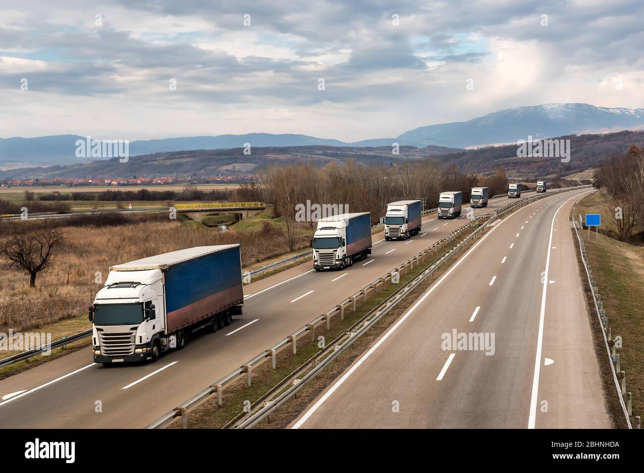 Convoy of transportation trucks in line as a caravan or convoy on a ...