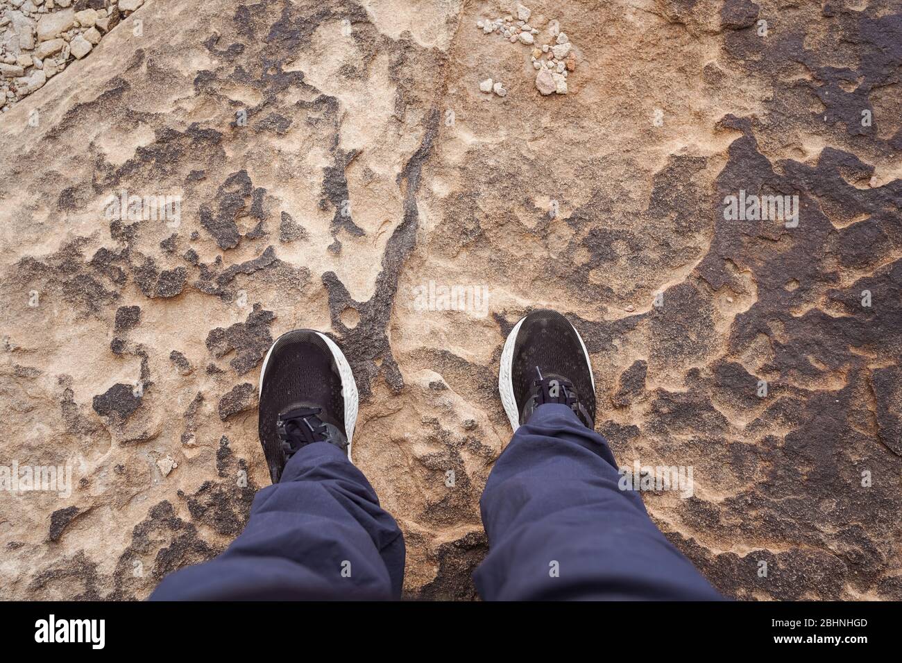 legs of man stepping on characteristic stone of Al-Habala canyon, Saudi ...