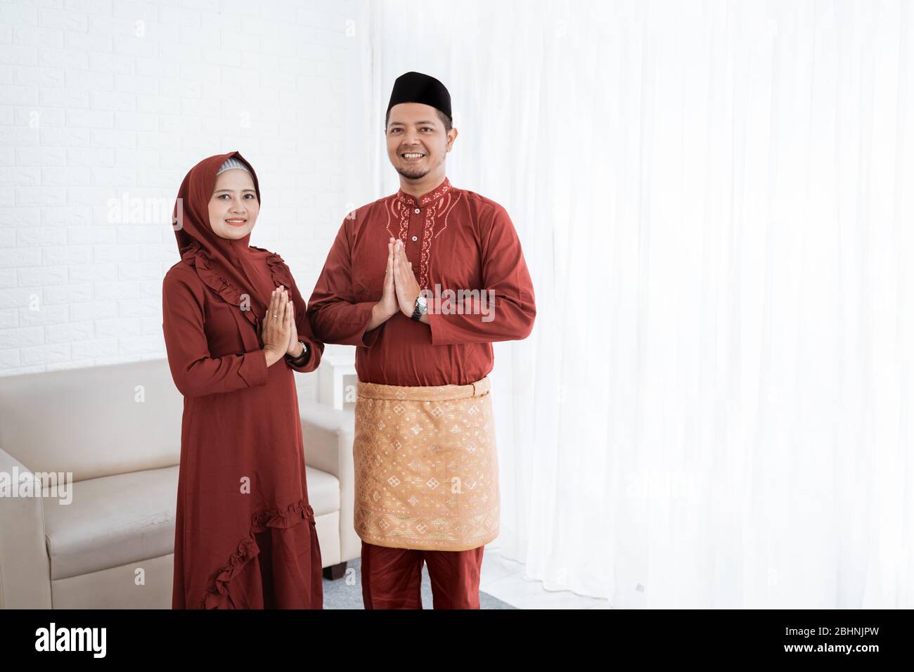 Asian couple smile standing up with gestures of apologize when wish ...