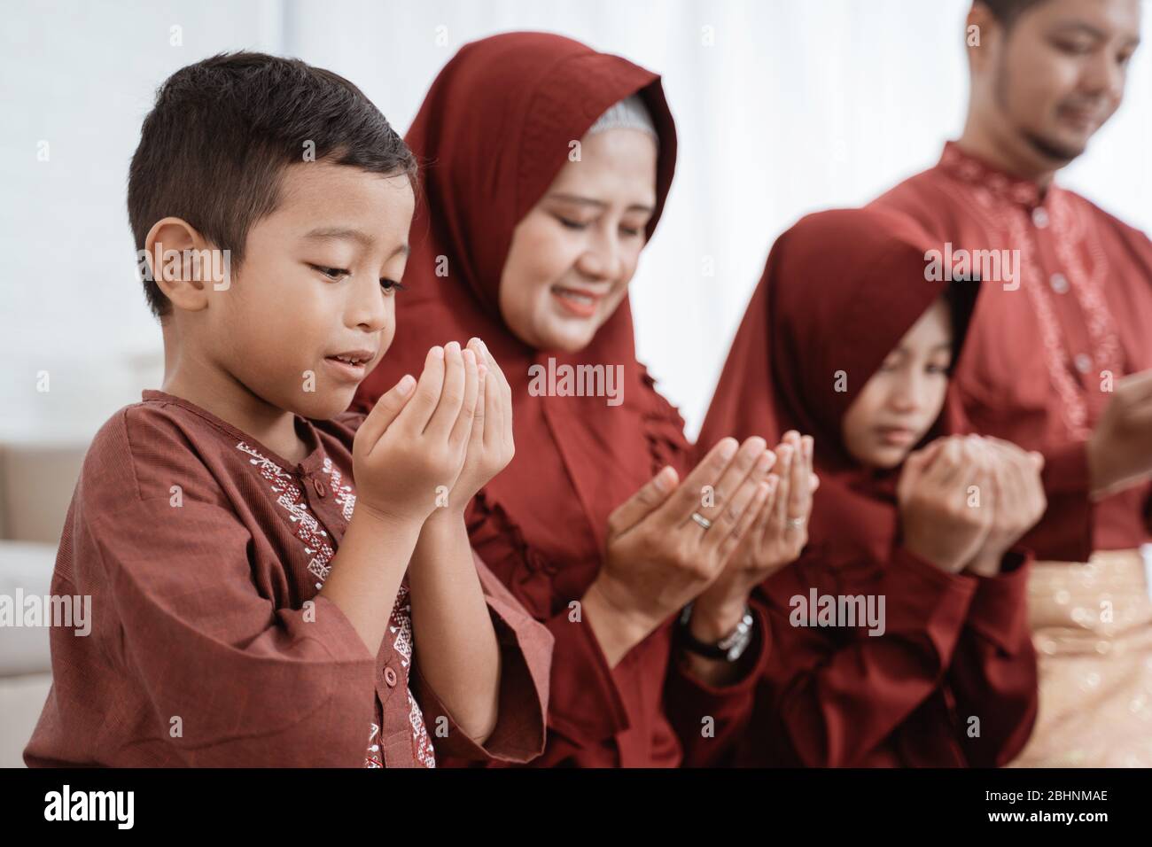 Muslim father,mother,daughter and son praying together at home Stock ...
