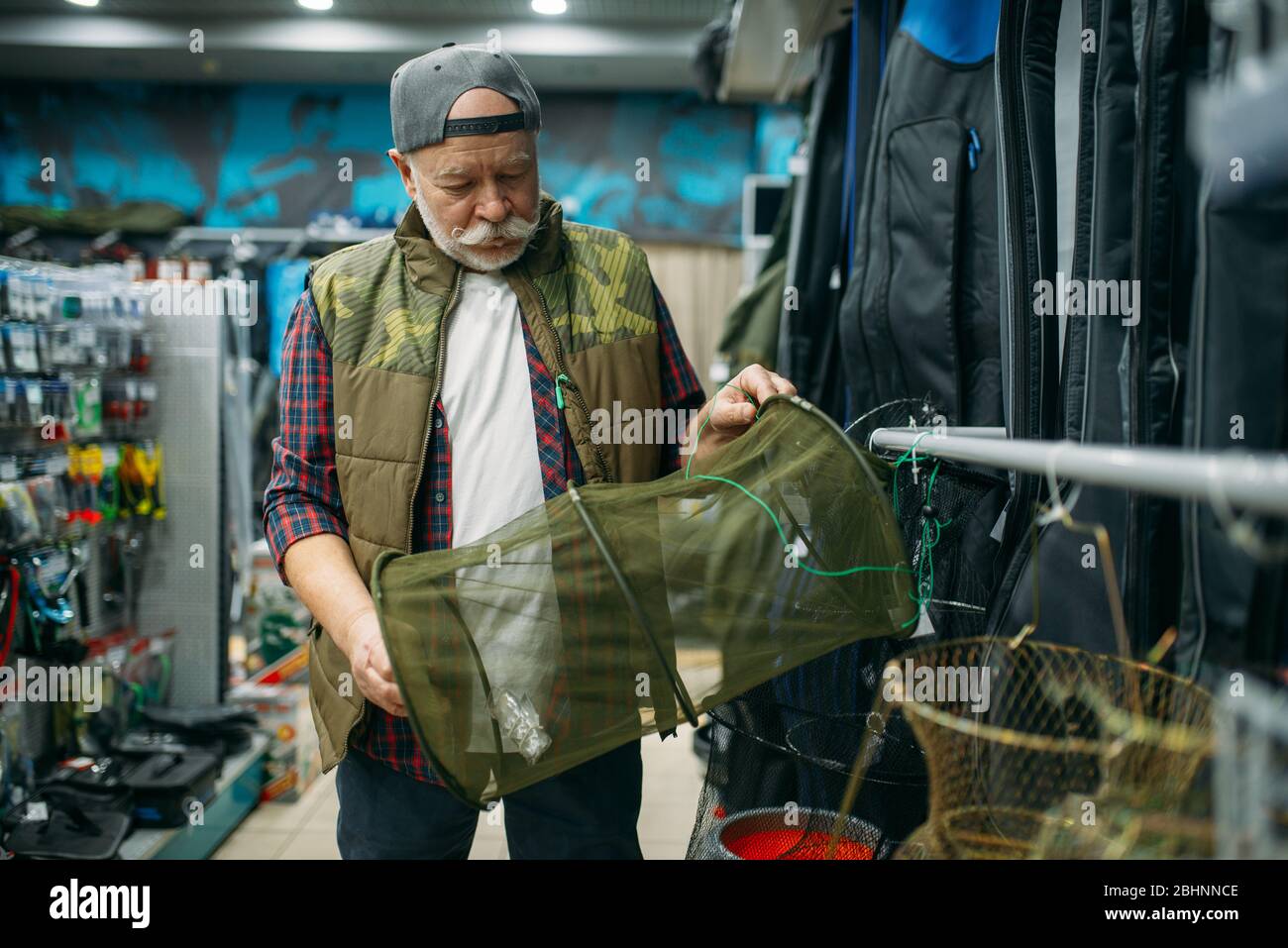 Male angler choosing net in fishing shop Stock Photo - Alamy