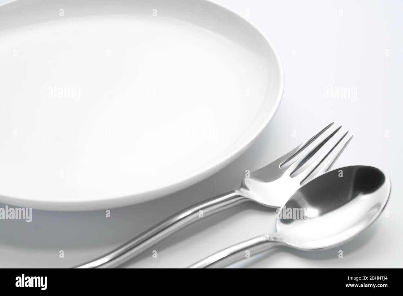 plate with fork and spoon isolated Stock Photo - Alamy