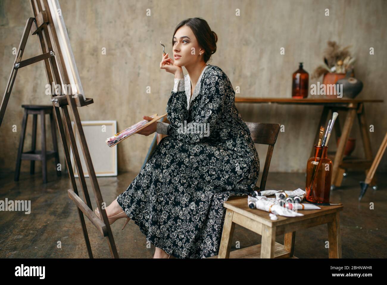 Female painter sitting at the easel in art studio Stock Photo - Alamy