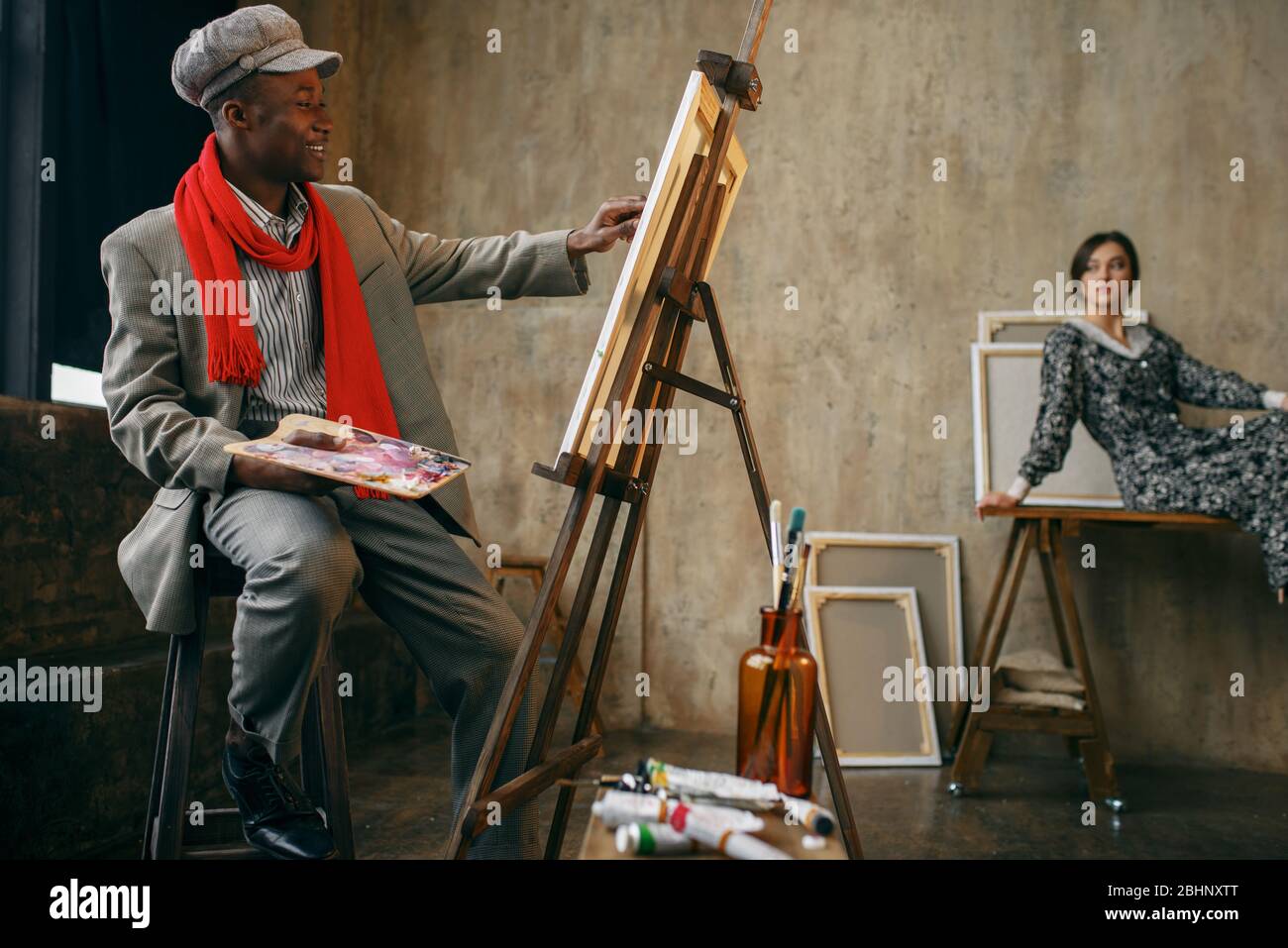 Happy painter draws female model in art studio Stock Photo - Alamy