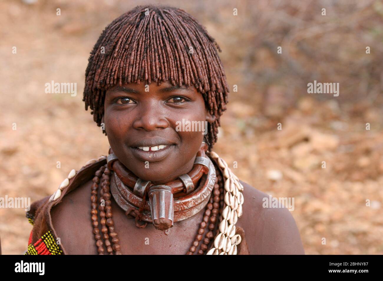 Portrait of a Hamer Tribeswoman. The hair is coated with ochre mud and ...