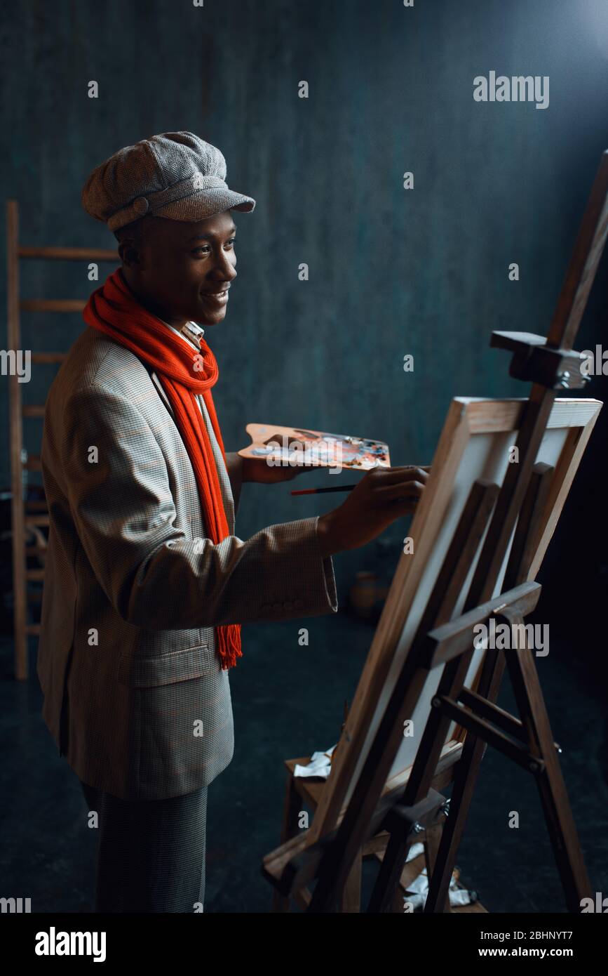 Fashionable painter with palette poses at easel Stock Photo - Alamy