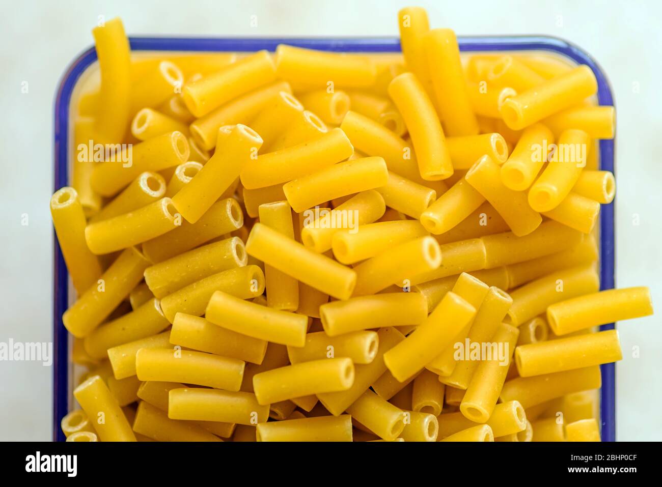 raw italian macaroni pasta inside clear storage container Stock Photo ...