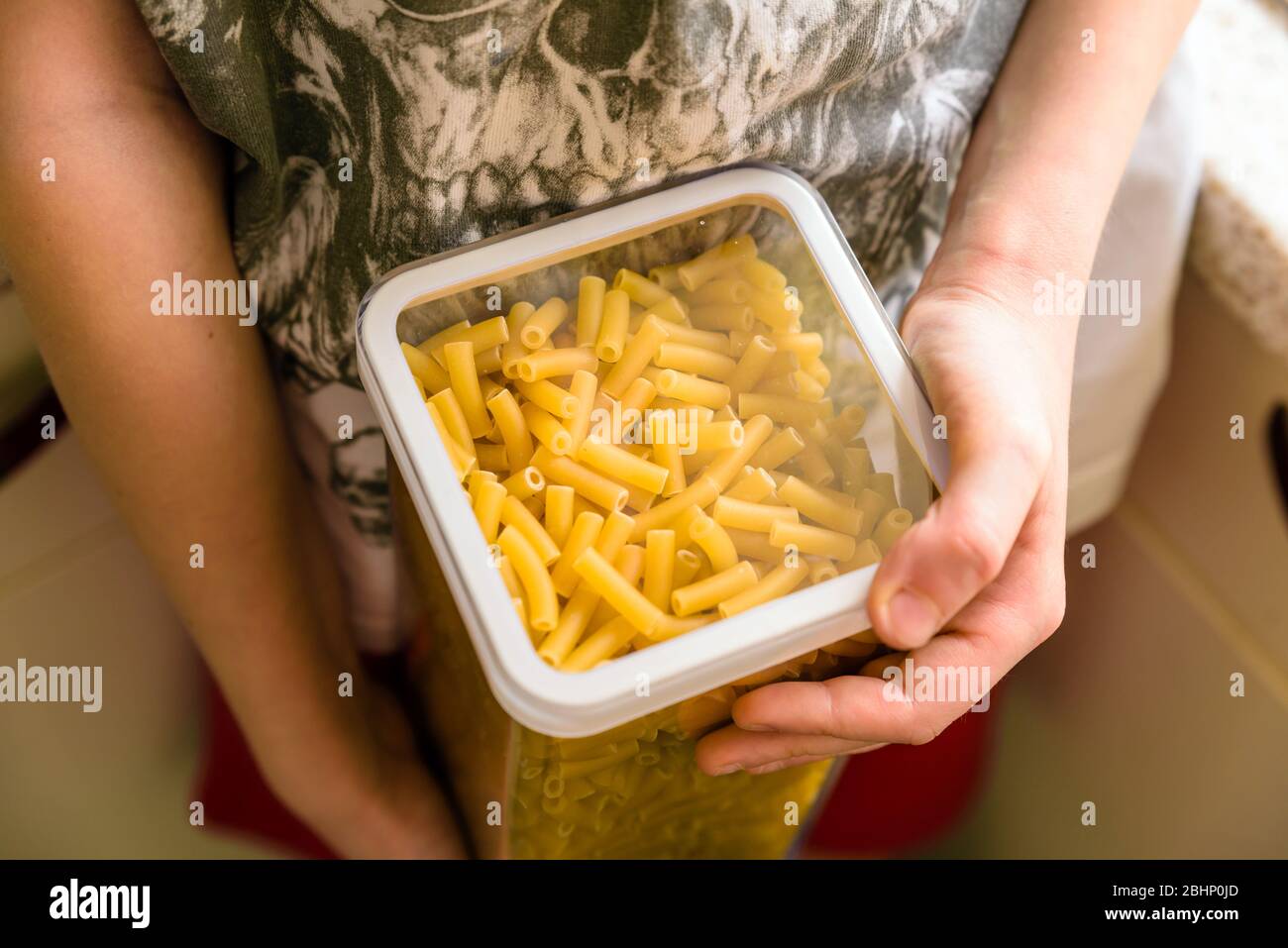 raw italian macaroni pasta inside clear storage container inside childs ...